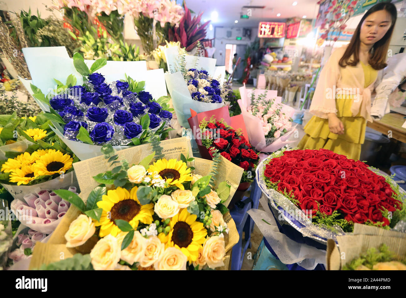 Chinese workers display flowers at a flower market ahead of traditional ...
