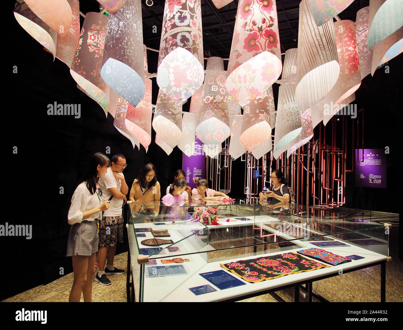 Visitors view an artwork featuring ethnic decorative patterns during an ...