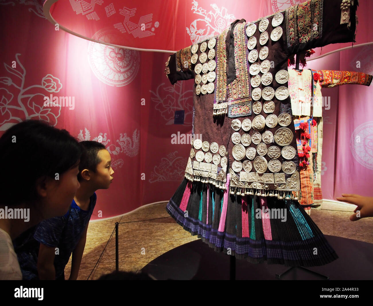 Visitors view a robe featuring ethnic decorative patterns during an ...