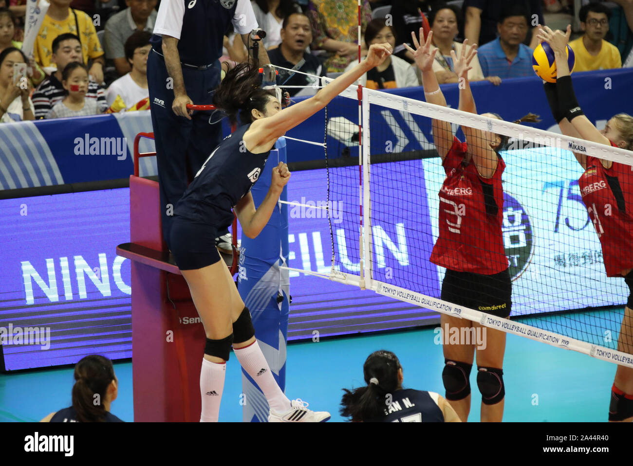 Zhu Ting, a member of China women's national volleyball team, the one in blue, jumps to smash ...