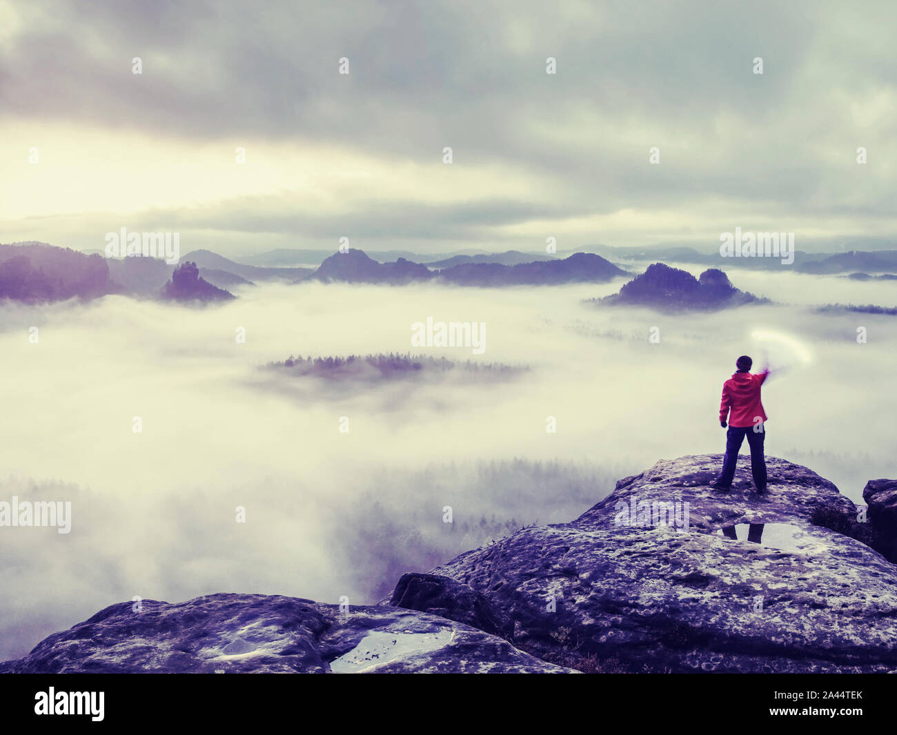 Back view of woman with flashlight standing on rocky bank, sharp light ...