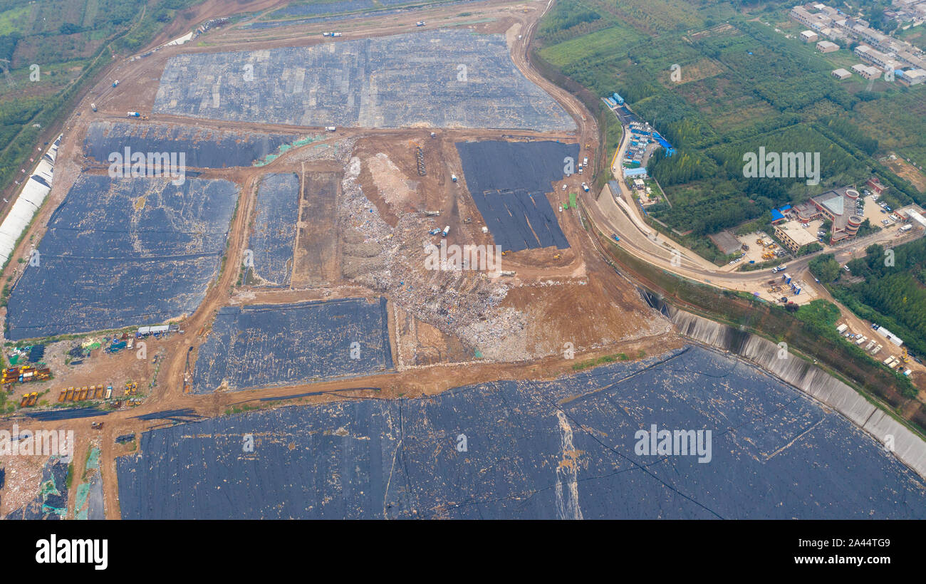Chinese workers sort out and bury kitchen waste at the Jiangcungou Landfill, which is the China ...