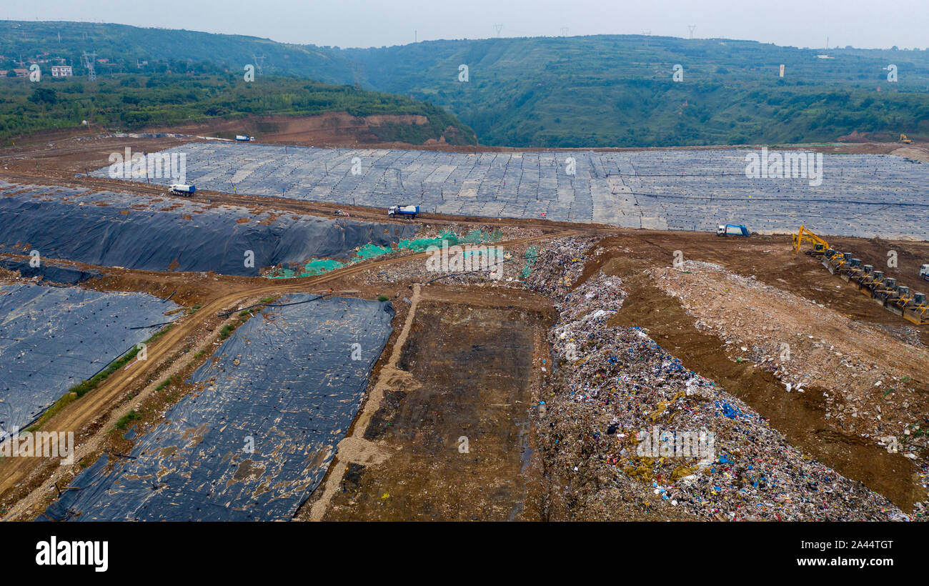 Chinese workers sort out and bury kitchen waste at the Jiangcungou ...