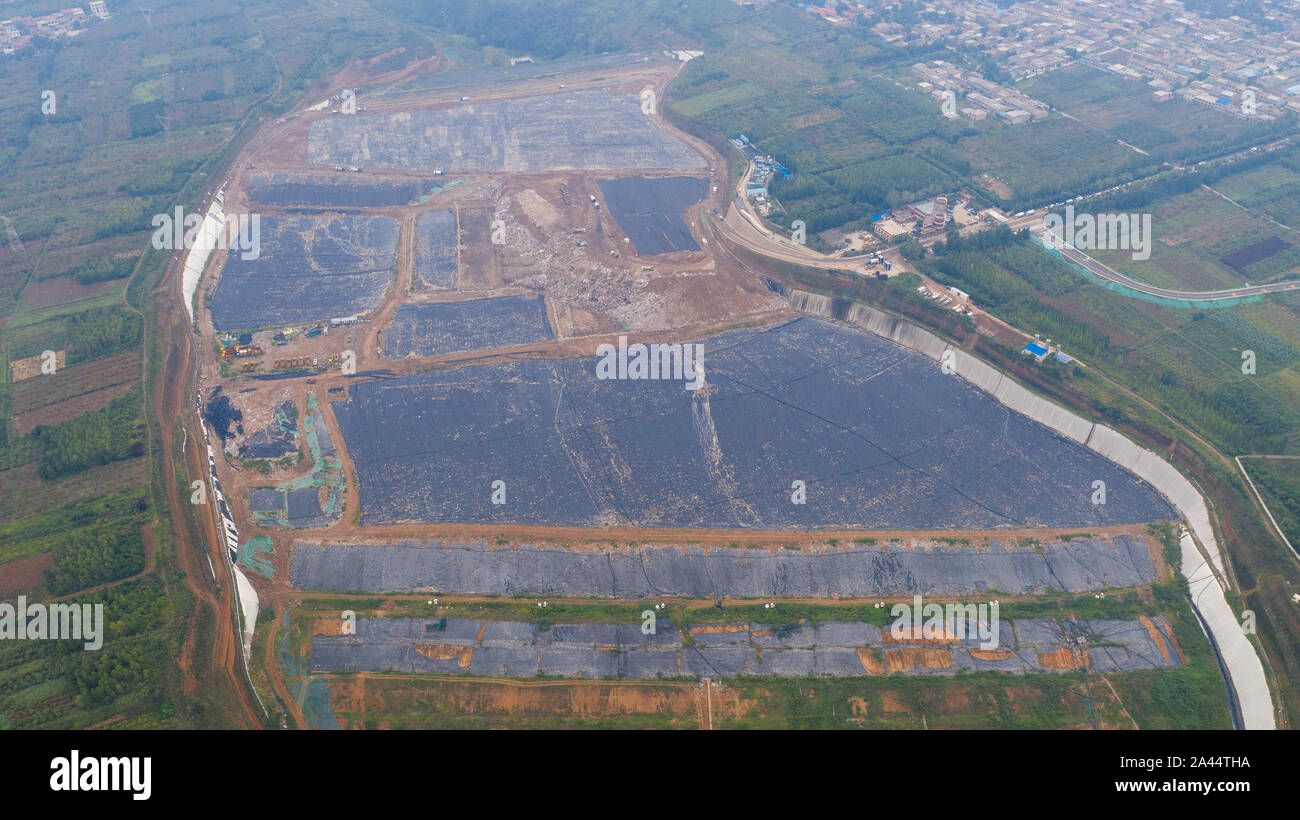 Chinese workers sort out and bury kitchen waste at the Jiangcungou ...