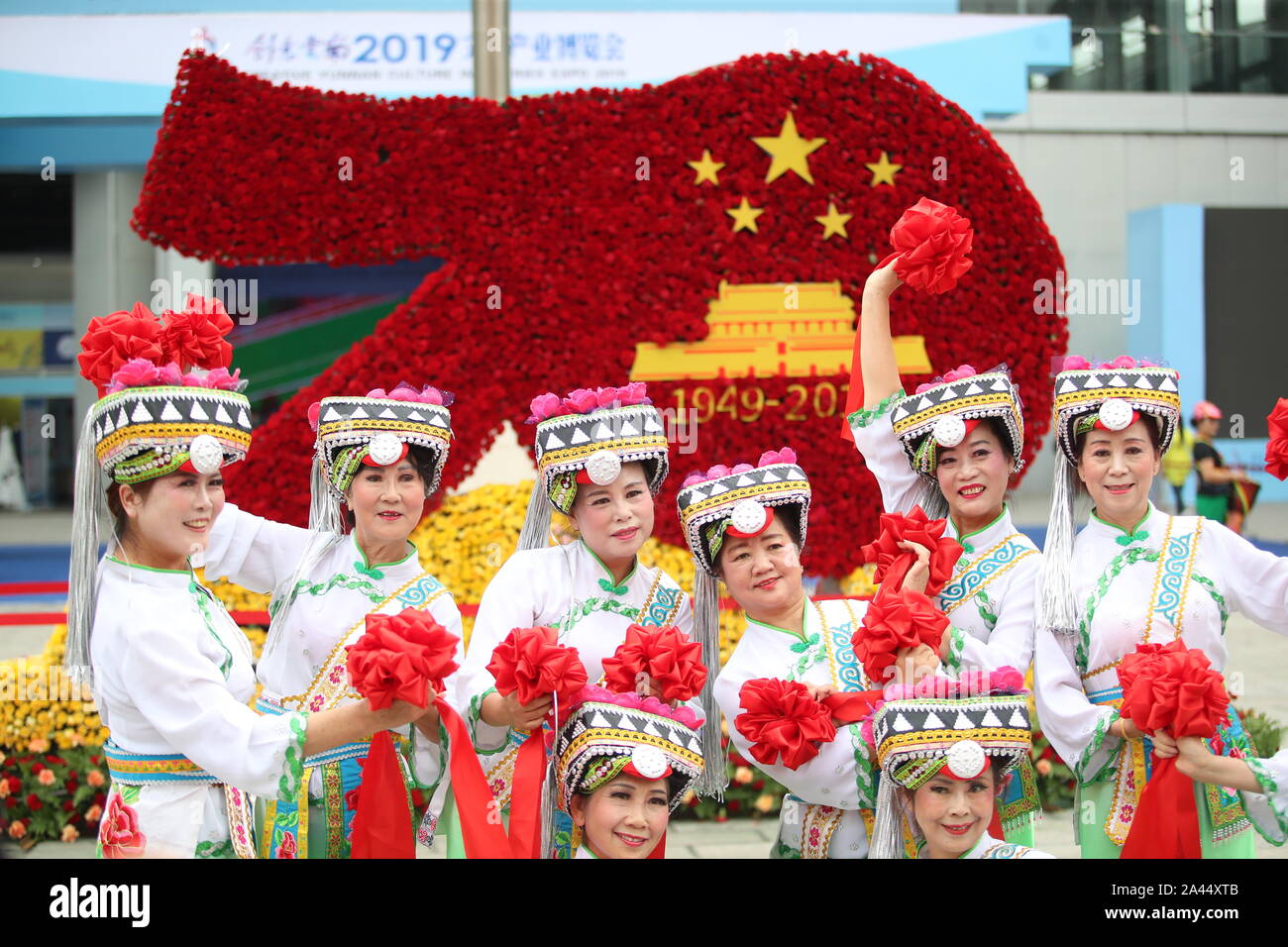 Chinese ethnic people dressed in traditional costumes perform during ...