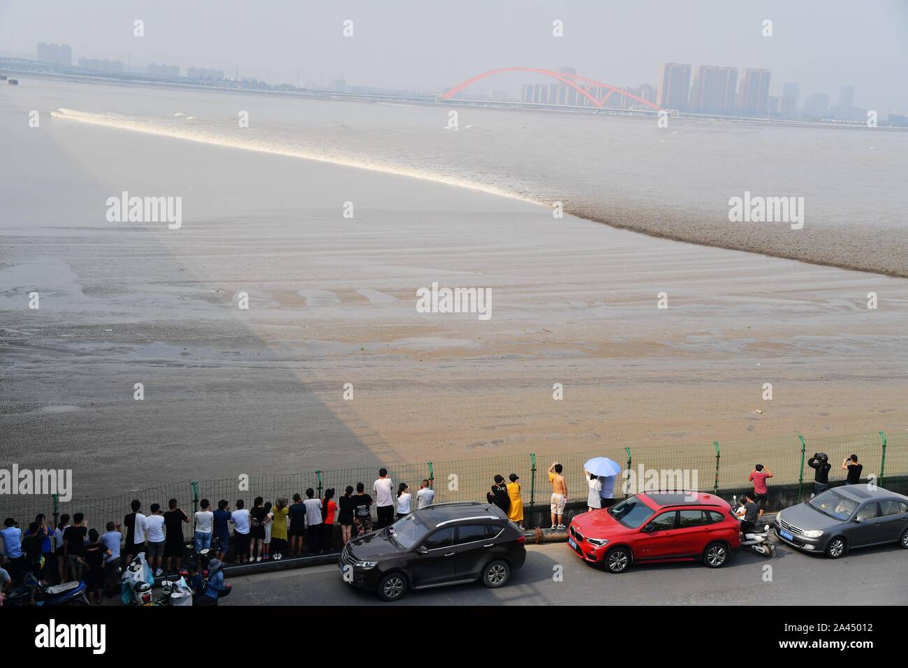 Visitors and local residents watch the tidal bore of the Qiantang River ...