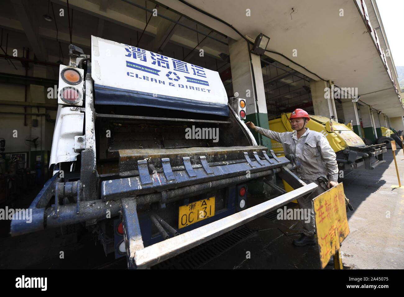 A Chinese worker unloads waste from a refuse truck at the Tianziling ...