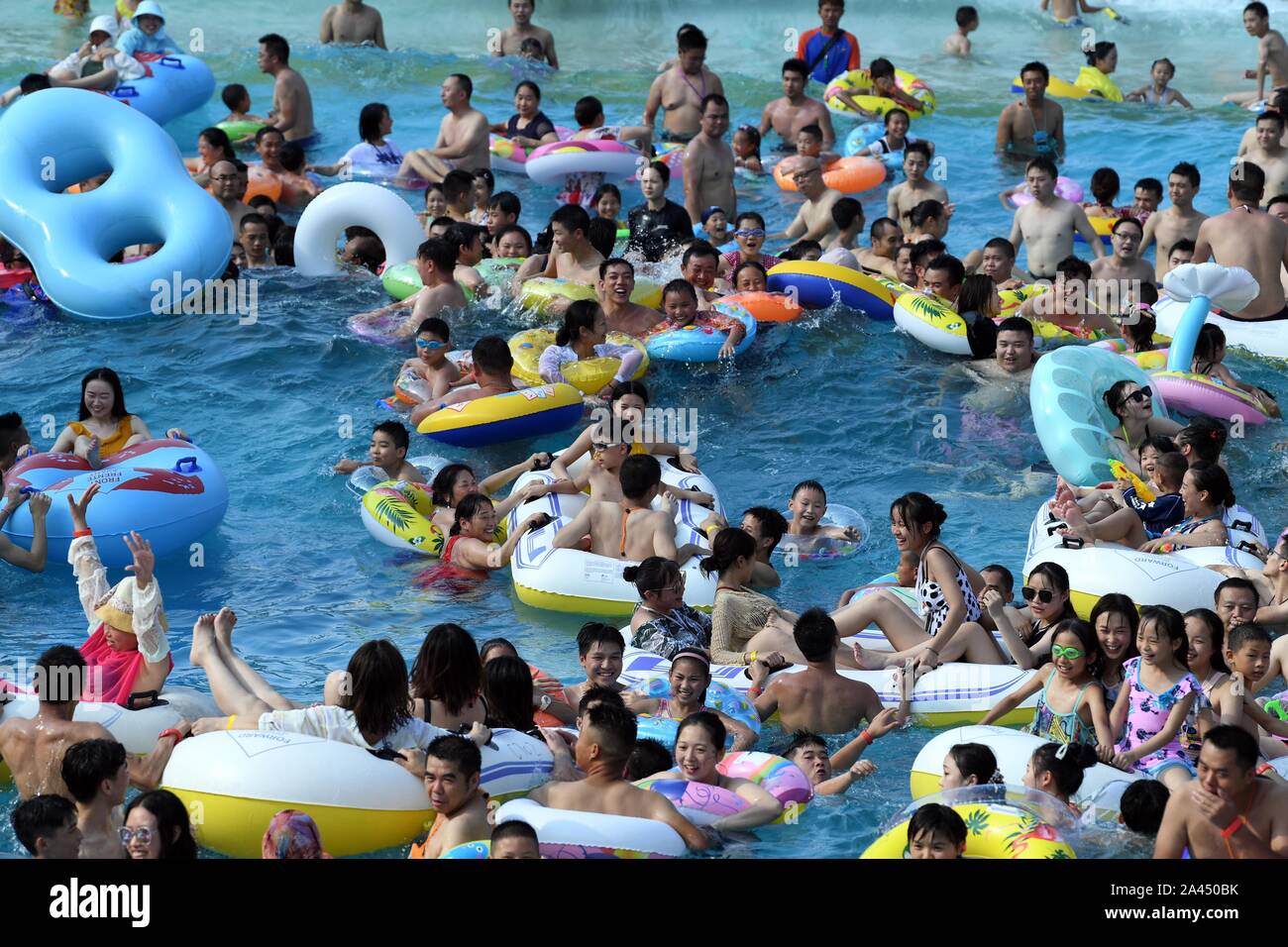 Chinese holidaymakers crowd a swimming pool at a water park to escape ...