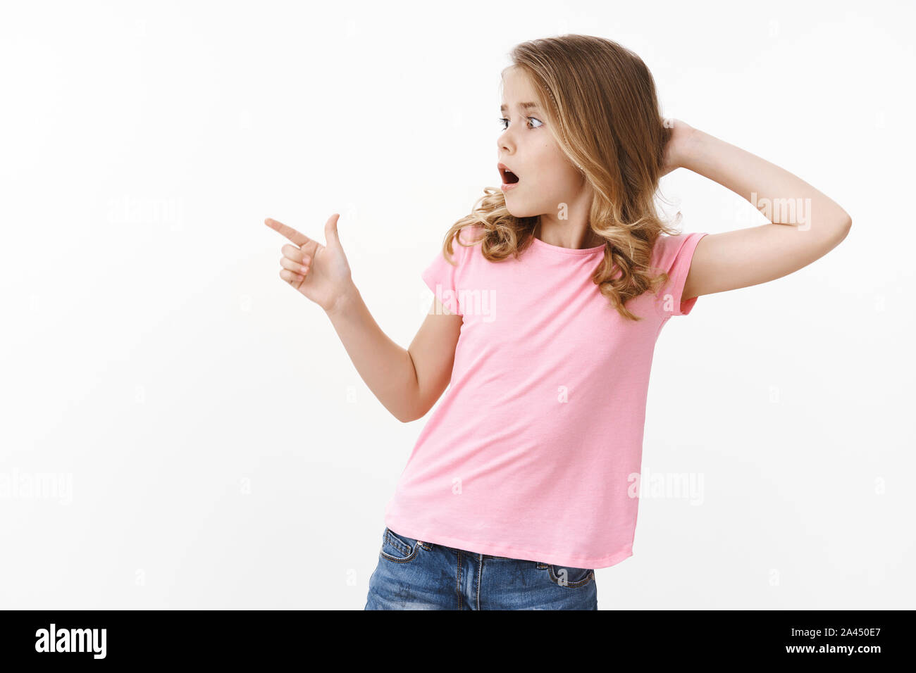Shocked amazed cute blond little girl kid, touch head stunned, turn ...