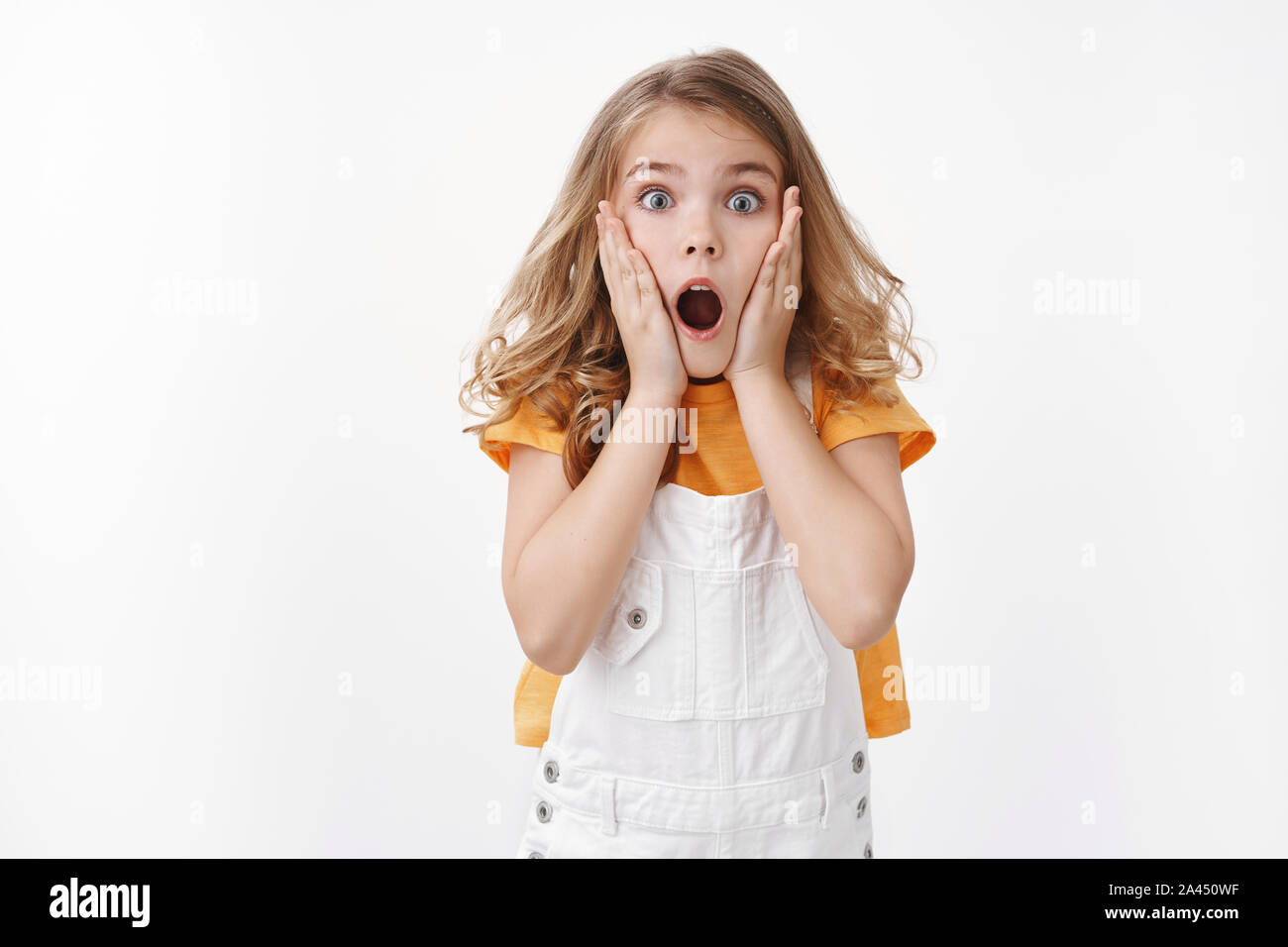Scared and shocked caucasian blond little girl gasping, grab face ...