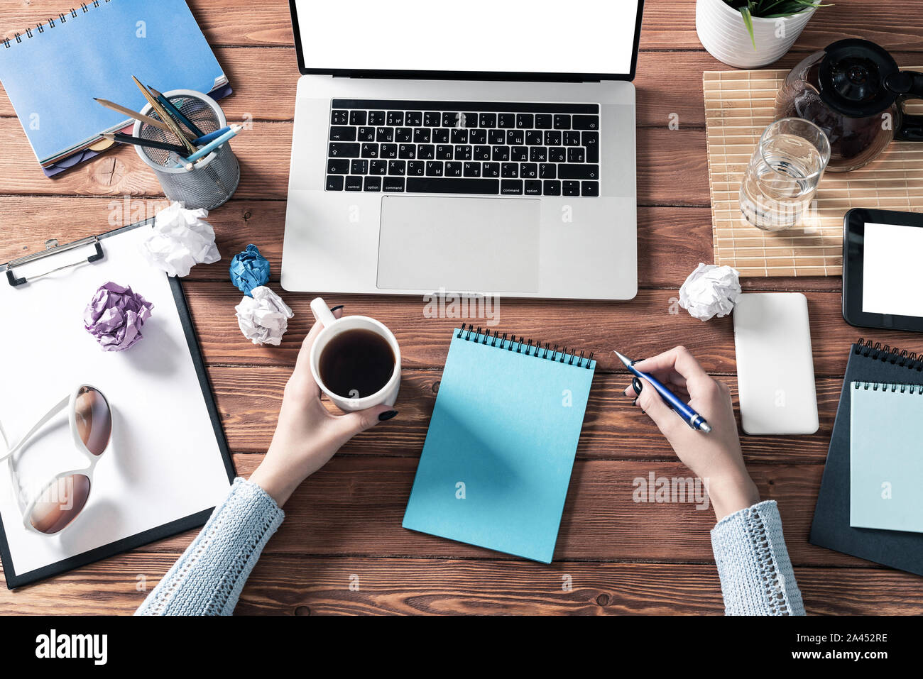 Business woman writing in notebook at office desk Stock Photo - Alamy