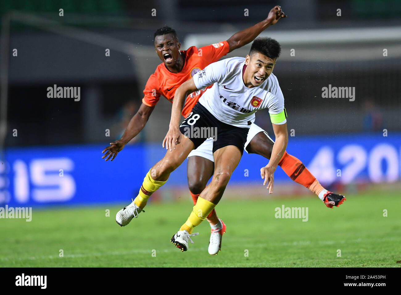 Kenyan football player Ayub Masika, left, of Beijing Renhe challenges a ...