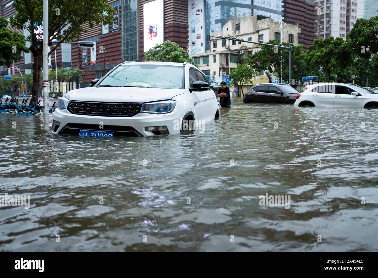 A car drives on a flooded road after a heavy rainstorm caused by ...