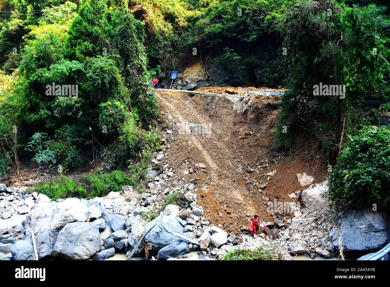 Chinese workers reconstruct a road devastated by floodwater after heavy ...