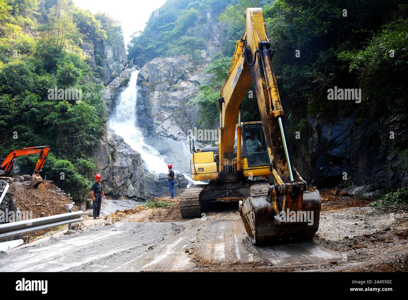 Chinese workers reconstruct a road devastated by floodwater after heavy ...