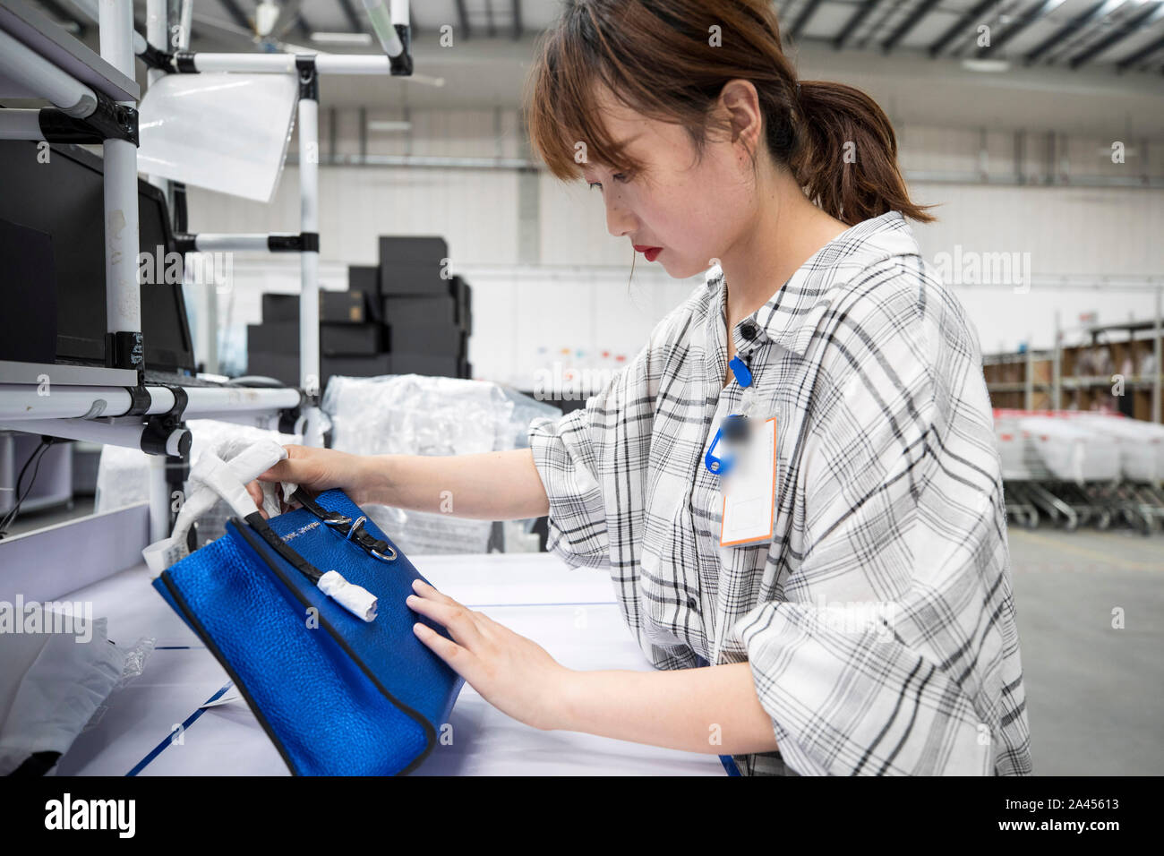 A treasure examiner examines a bag at east China's bonded warehouse in ...