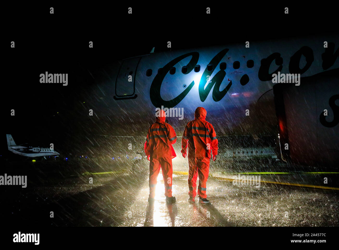 Chinese ground crew members fixate an airplane of Spring Airlines ahead ...