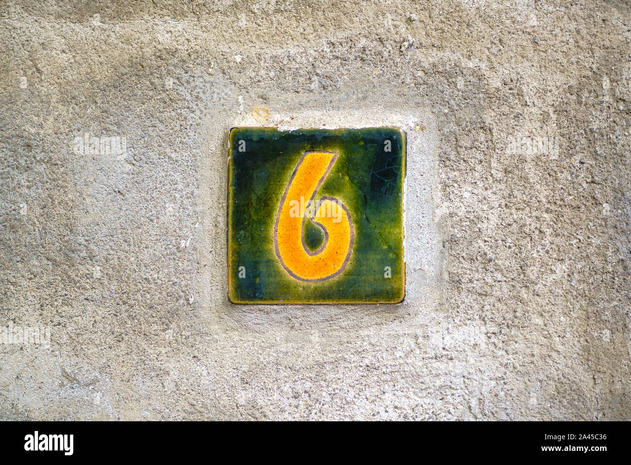 ceramic house number six (6) on a wall plastered with cement Stock ...