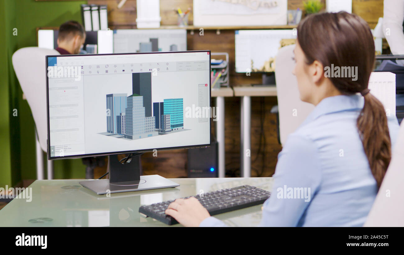 Female architect making 3d building models on computer. Architect holding blueprint Stock Photo ...
