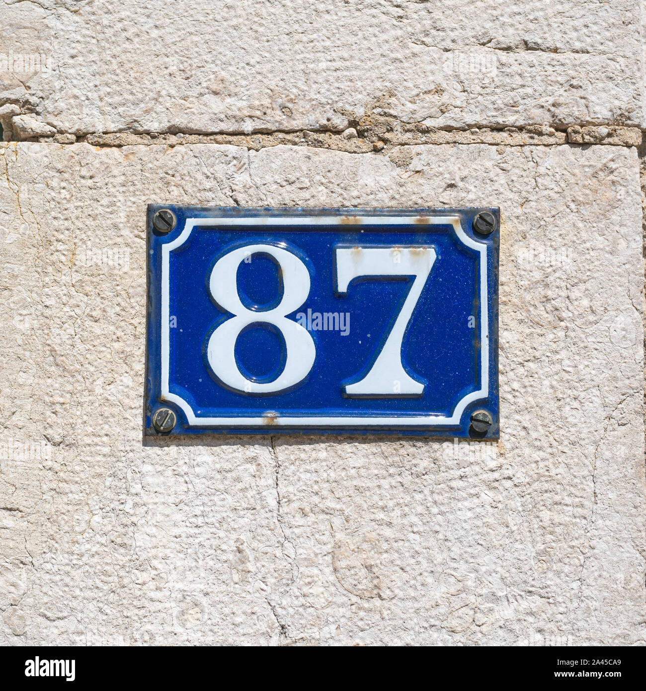 enameled house number eighty seven (87) on a stone wall Stock Photo - Alamy