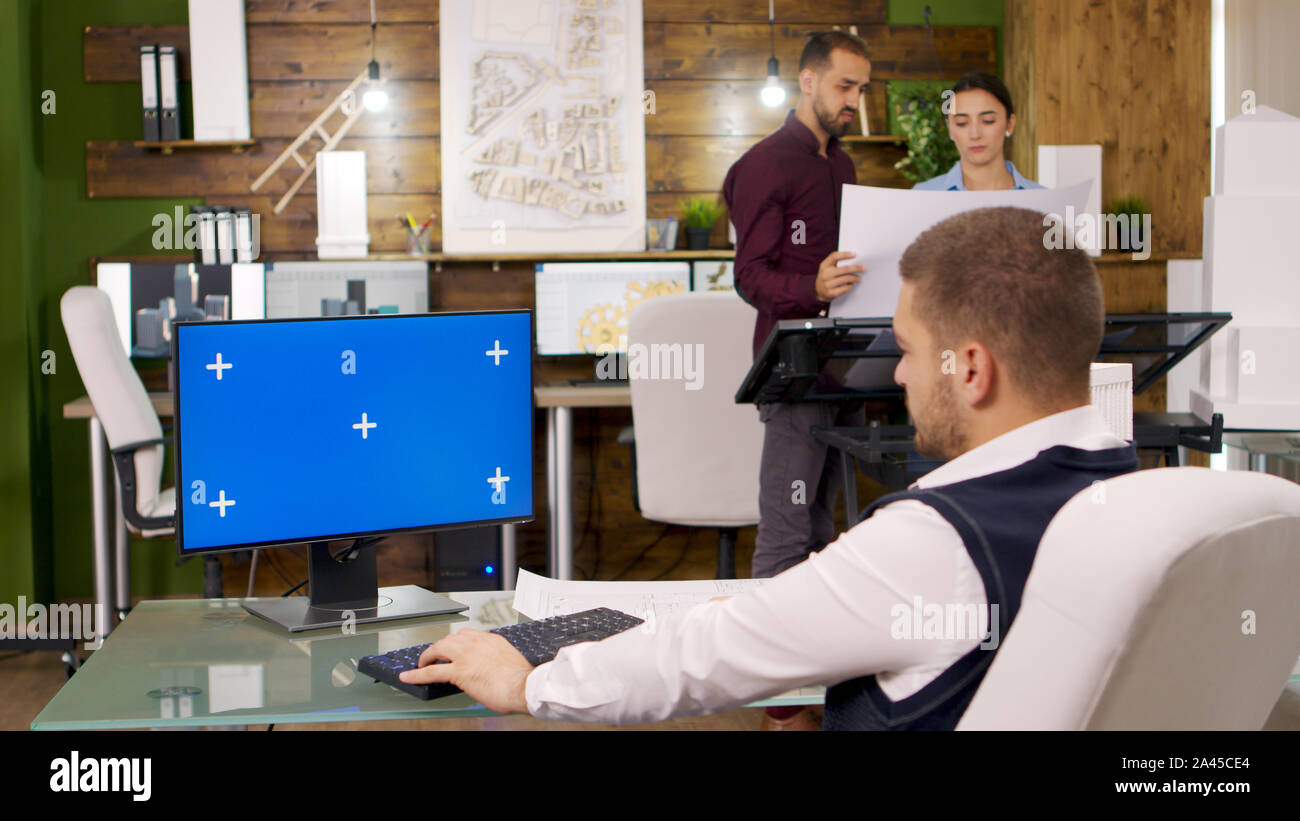 Creative architect working on computer with blue screen. Architects ...