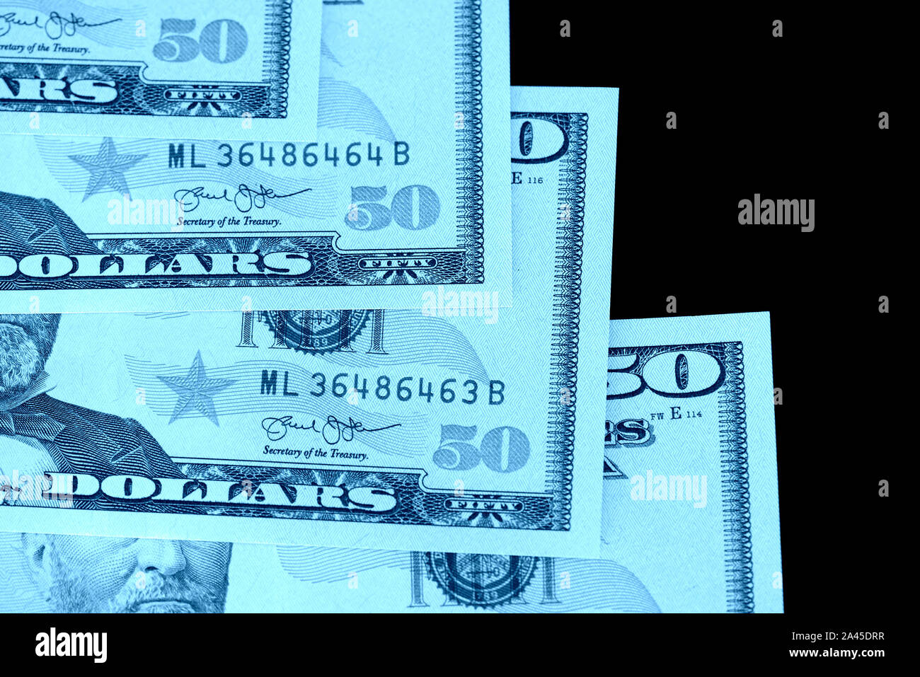 Fifty dollars banknotes isolated on black background close-up. Blue ...