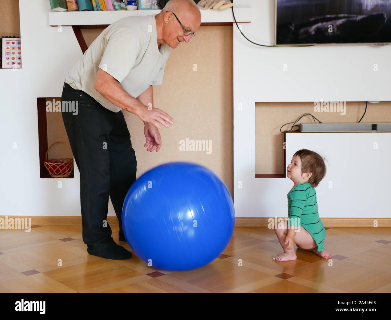 the child plays with the grandfather a ball. play a big blue ball at ...