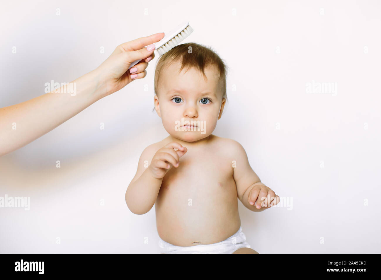 Mother hand combing hair for her Baby girl 1 year old, isolated on ...