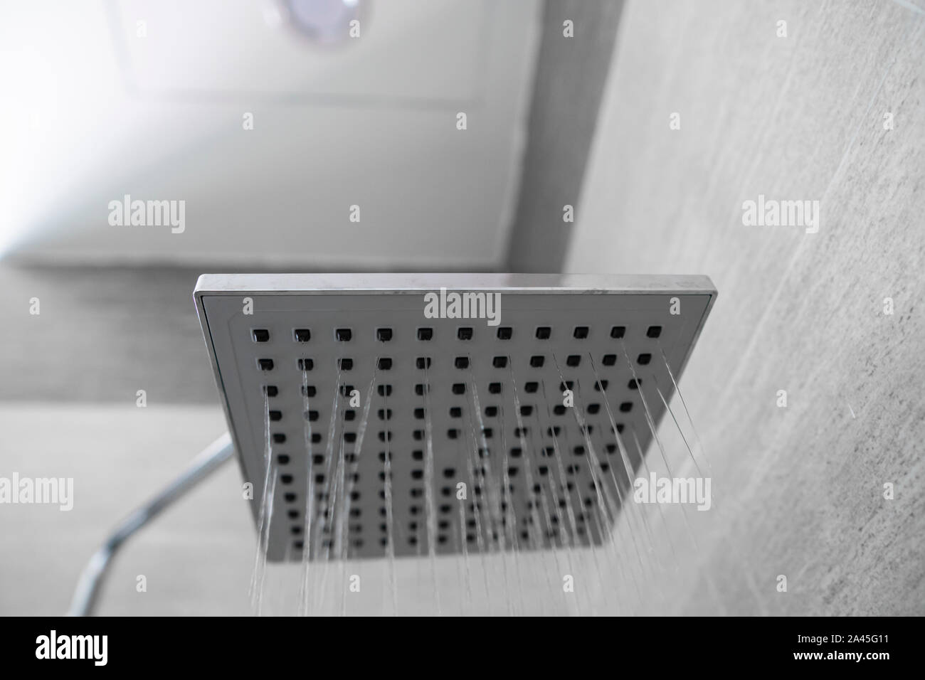 Water flowing from the square shower head in a modern bathroom. Shower ...