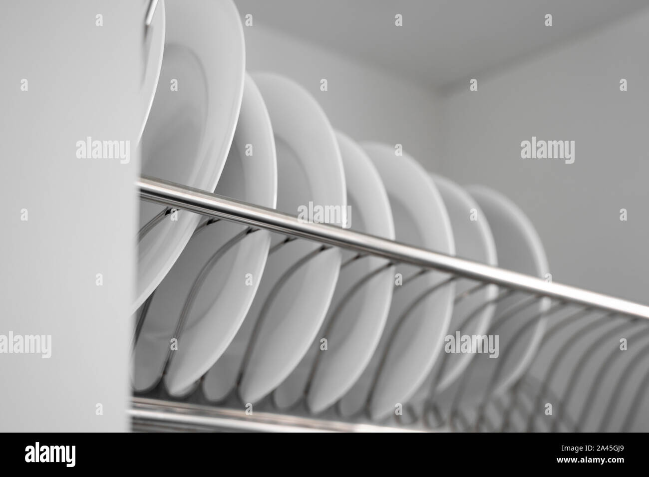 Dish drying metal rack with big nice white clean plates. Traditional ...