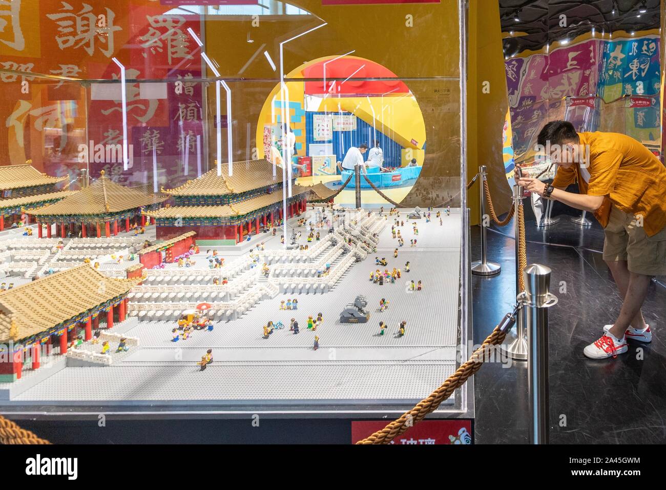 A visitor takes pictures of the Lego toy model of the Forbidden City ...