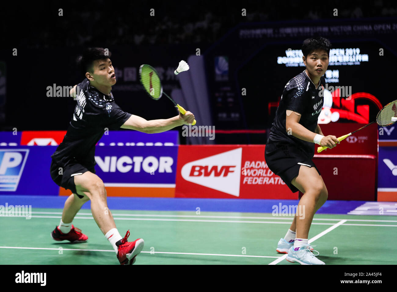 Chinese professional badminton players Wang Yilv and Huang Dongping compete against Chinese ...