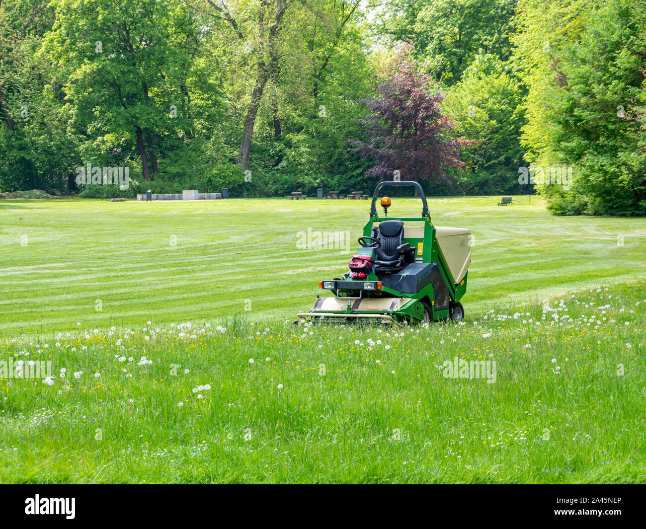 Lawn tractor in green maintenance Stock Photo - Alamy
