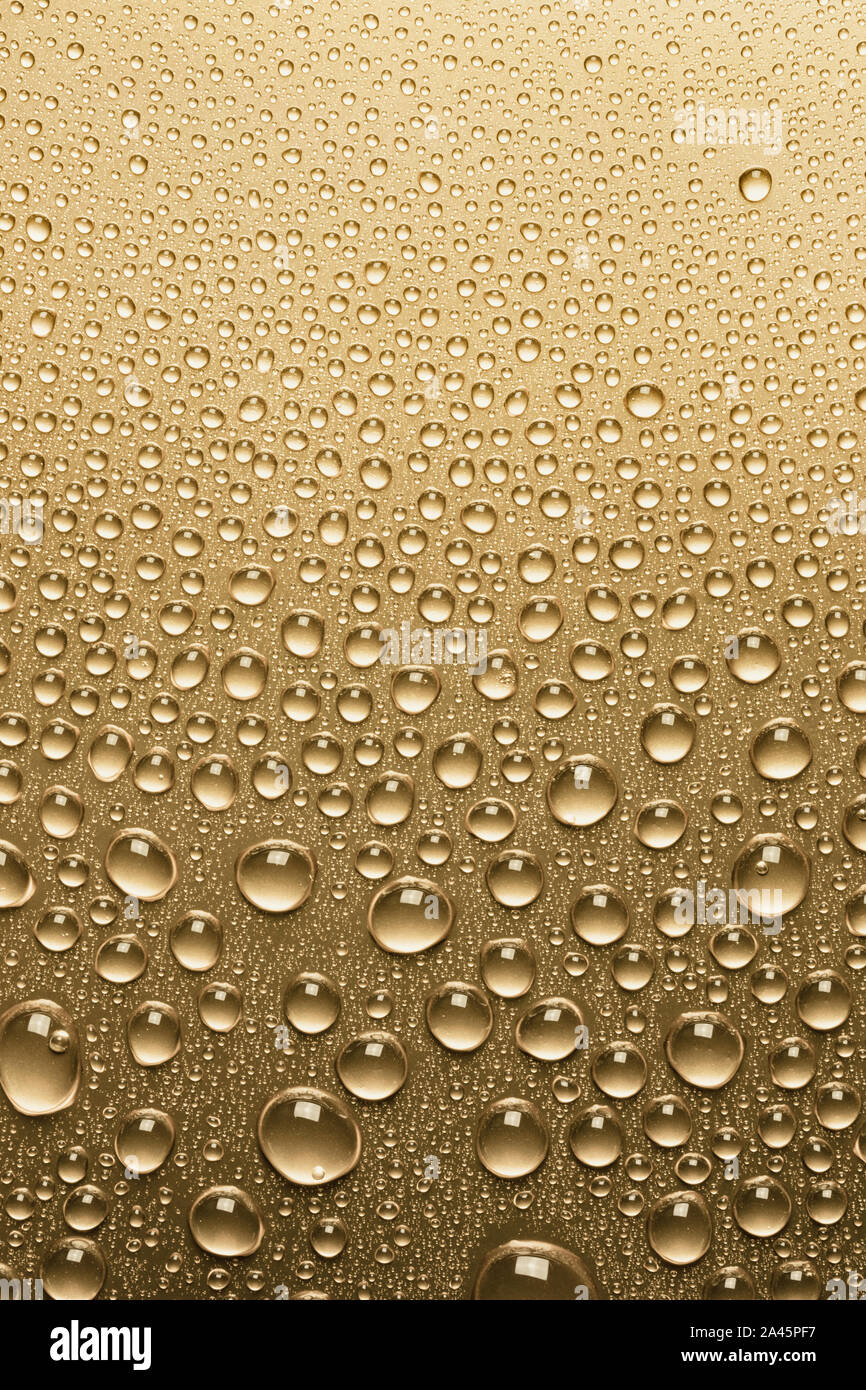 Close-up of water drops on surface, gold background Stock Photo - Alamy