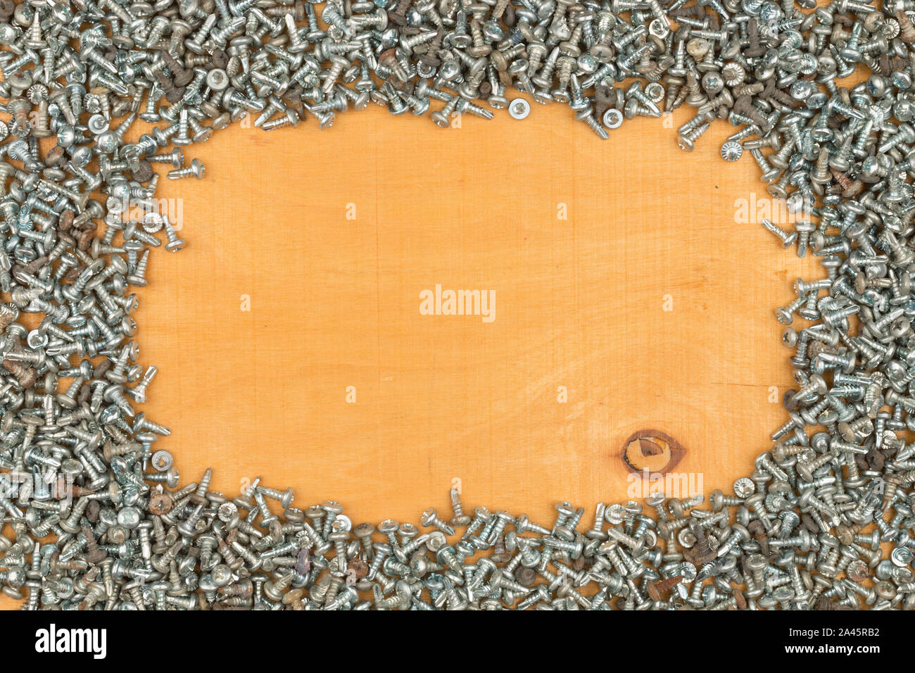 Frame made of screws on a wooden background, copy space. With space for ...