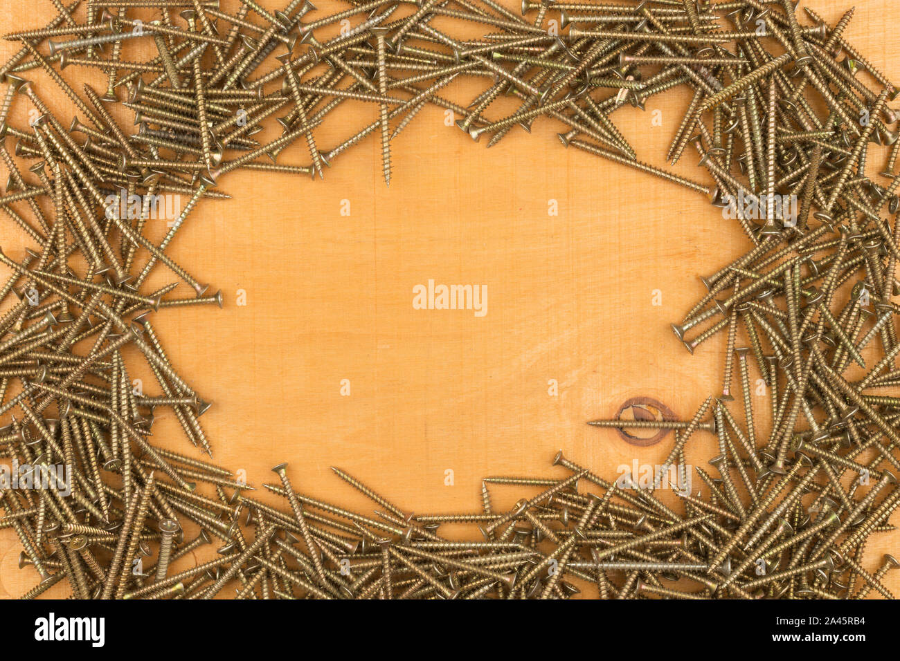 Frame made of screws on a wooden background, copy space. With space for ...