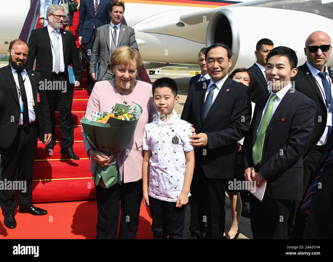 German chancellor Angela Merkel, pink, takes picture with a child who ...