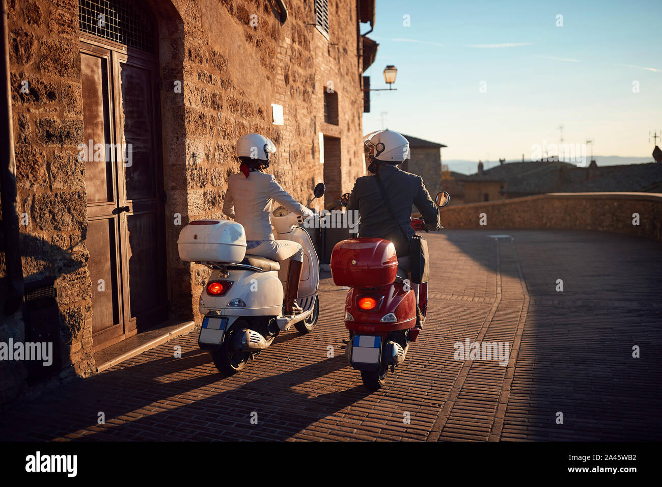 Young man and woman on Vespa Scooter. Bikers couple Stock Photo - Alamy