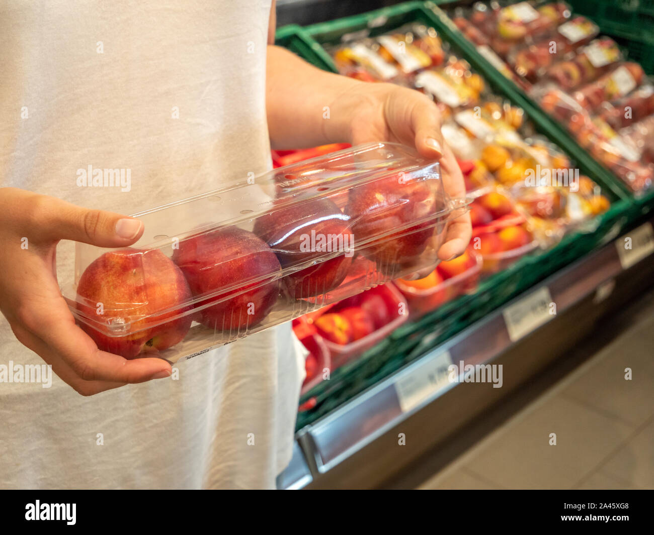 Peach in a plastic wrapper in the supermarket Stock Photo - Alamy