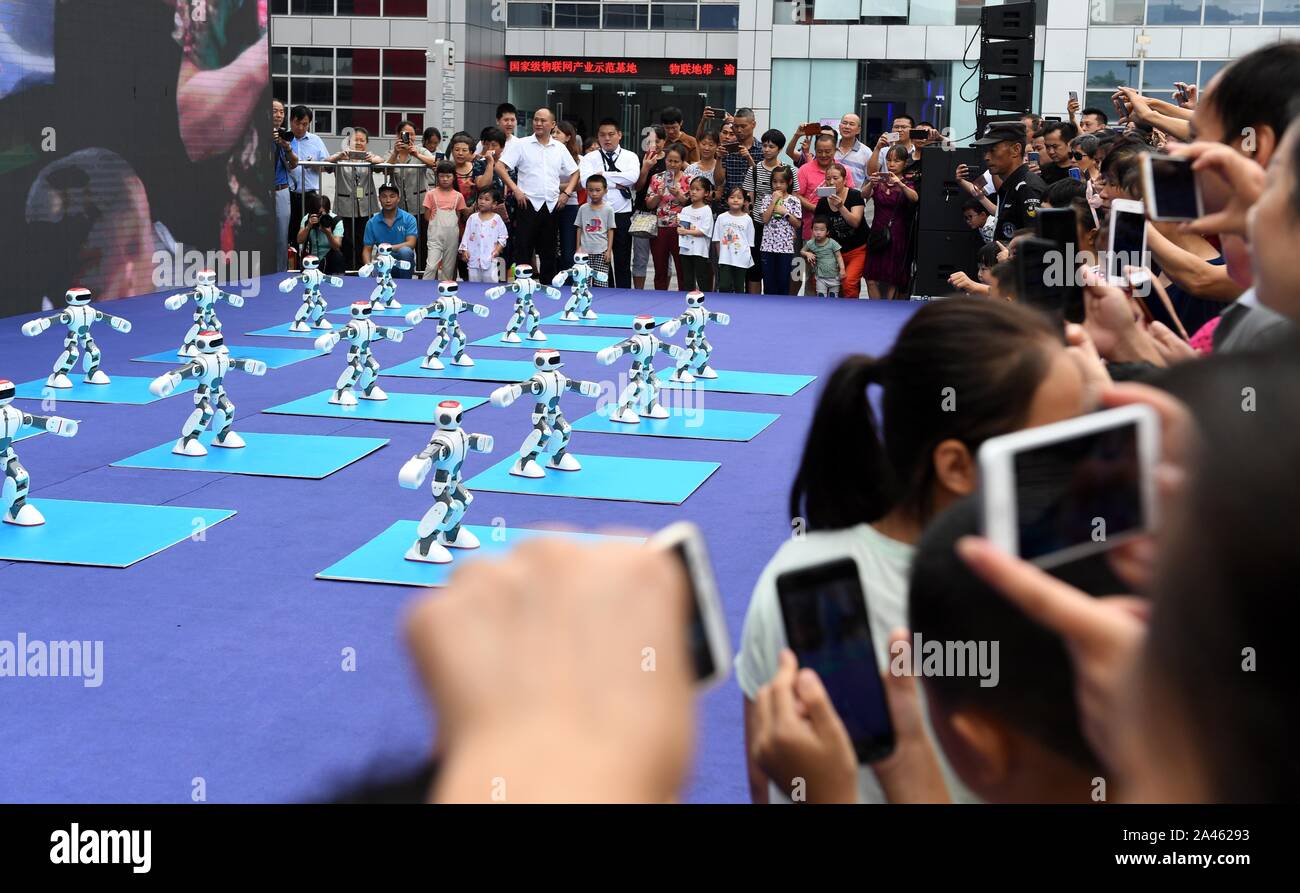 People watch robots dance in a park in Chongqing, China, 28 August 2019 ...