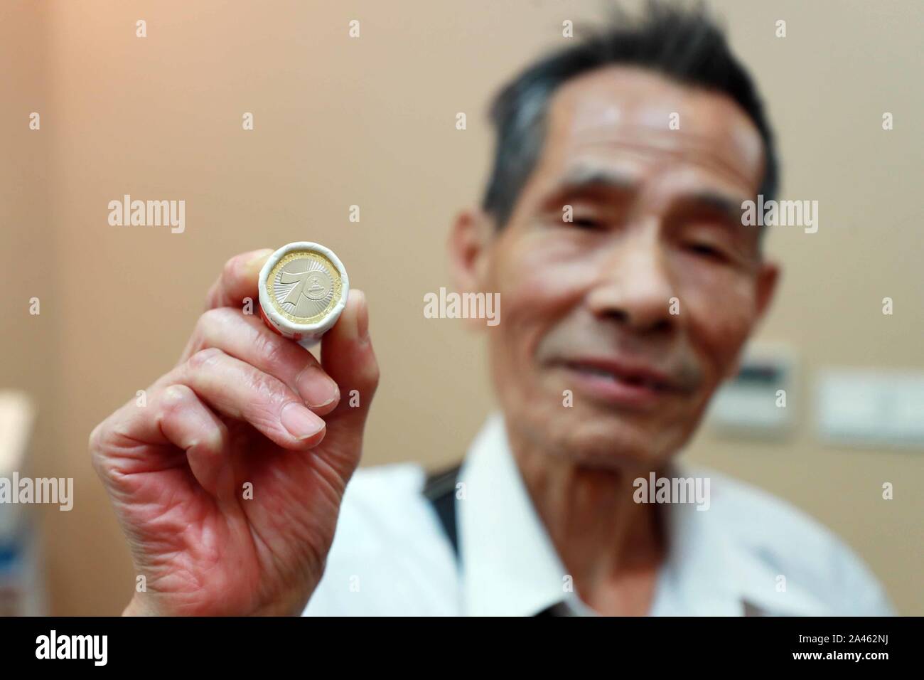 A commemorative coin lover demonstrates his gain of the 10 Yuan ...