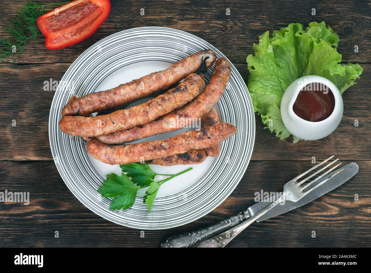 A grilled sausages on a plate on a kitchen table background Stock Photo ...