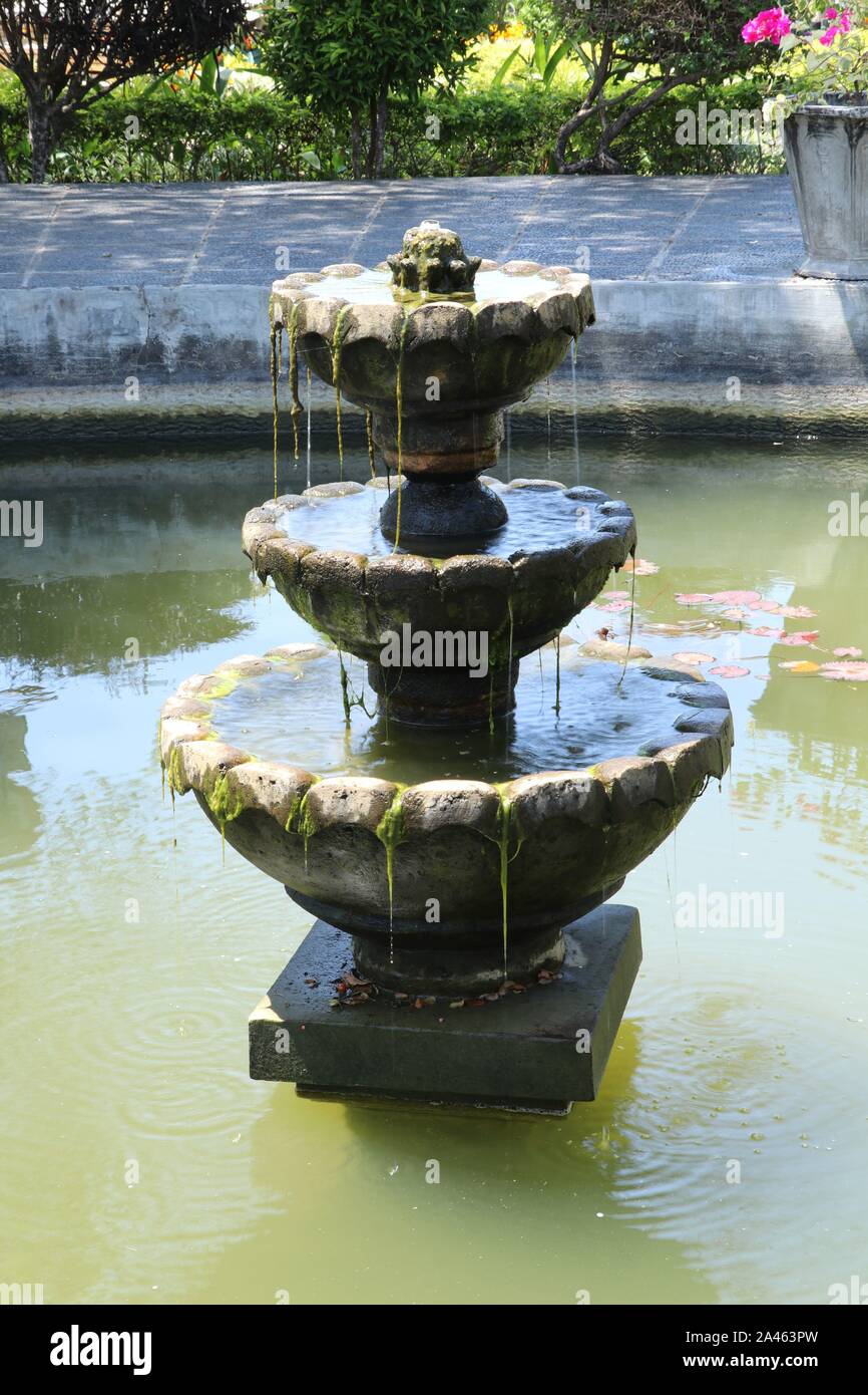 Three-level fountain in an ornamental pond. Weak streams of water spill ...