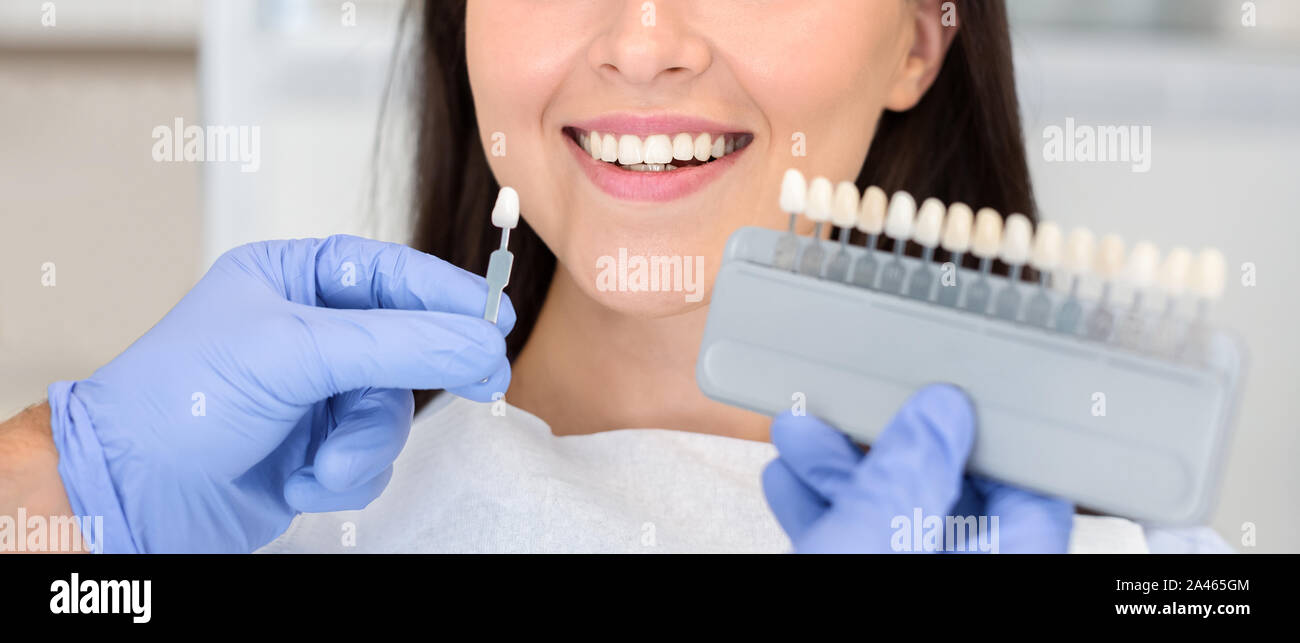Dentist applying sample from tooth scale to happy patient teeth Stock ...