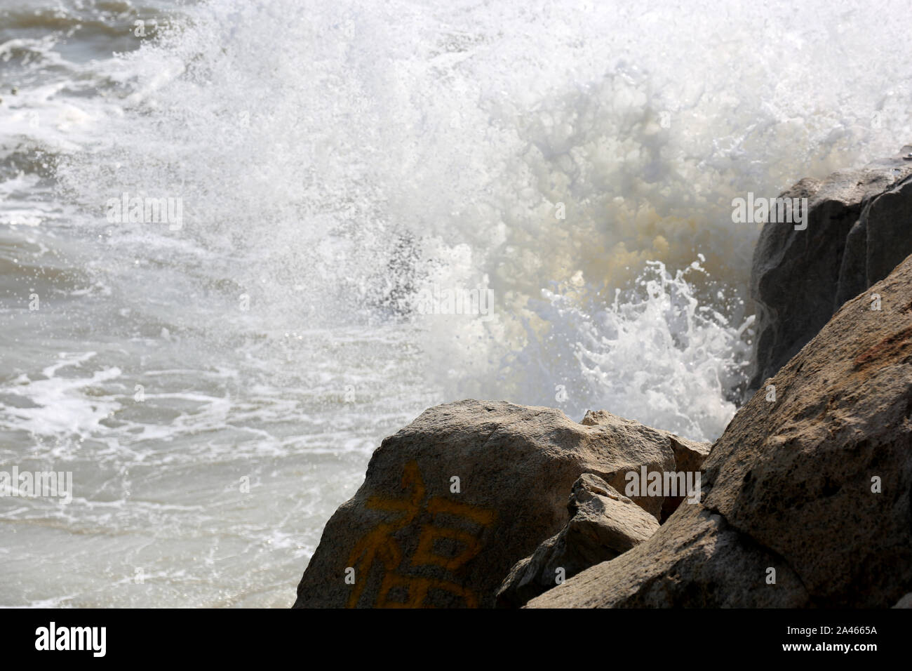 Visitors watch sea waves by the dam near the sea in Lianyungang city ...