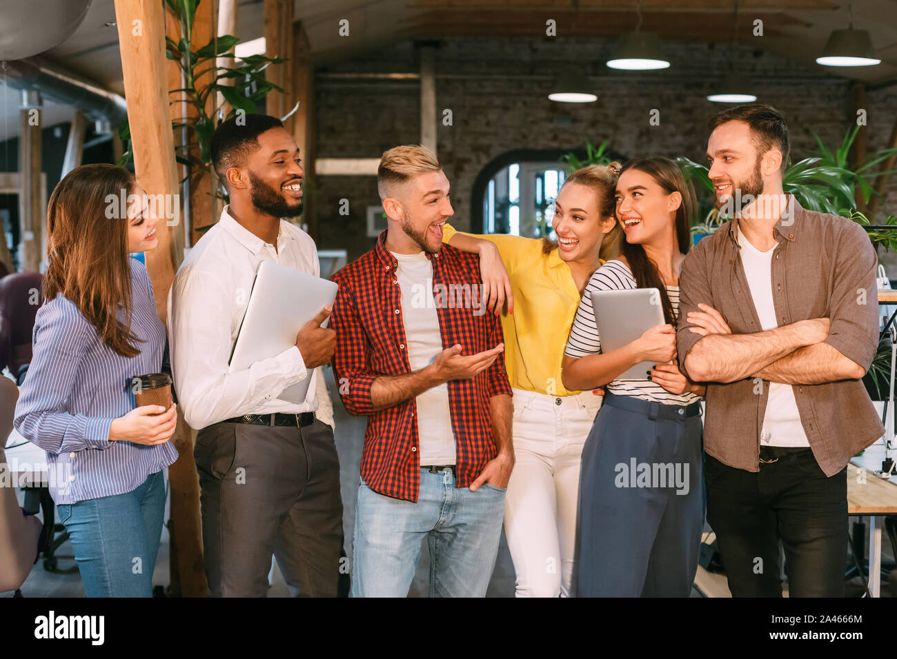 Successful workers having break, talking and laughing Stock Photo - Alamy