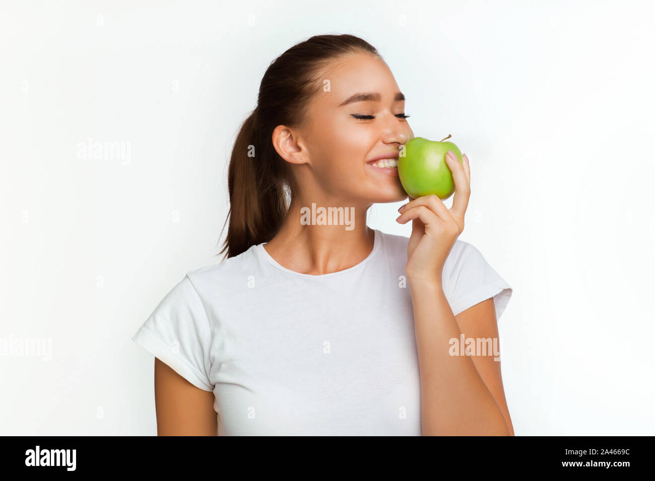 Girl eating apple over white hi-res stock photography and images - Alamy