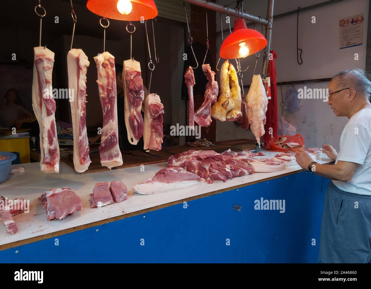 People shop for pork at a butcher's stall in Yichang city, central ...