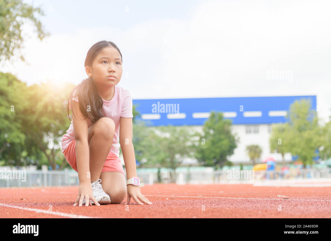 Cheerful cute girl in ready position to run on track, healthy and ...