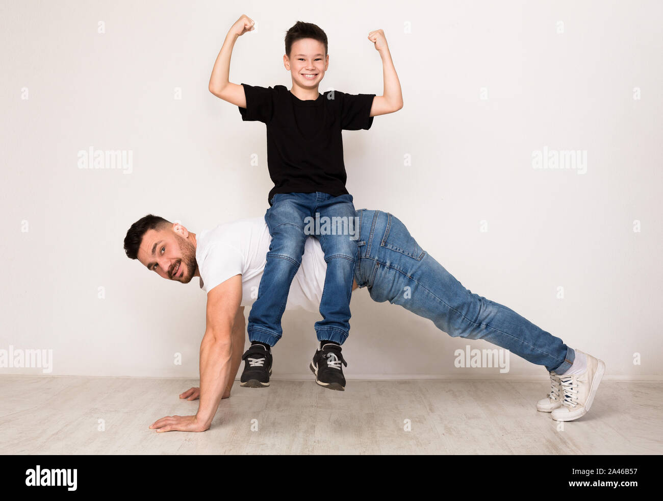 Strong dad doing push ups with son on back Stock Photo - Alamy